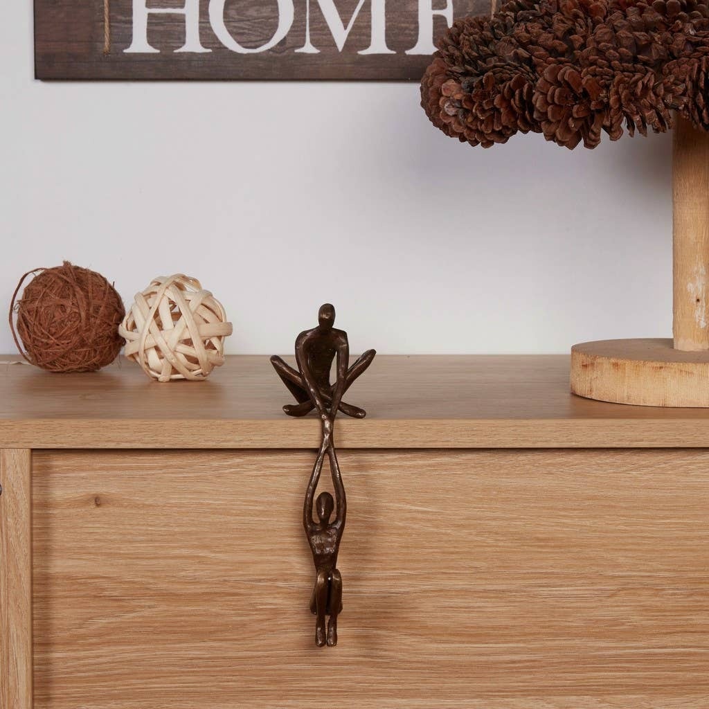 Man Lifting Woman from Ledge Bronze Sculpture | Mr. Walrus